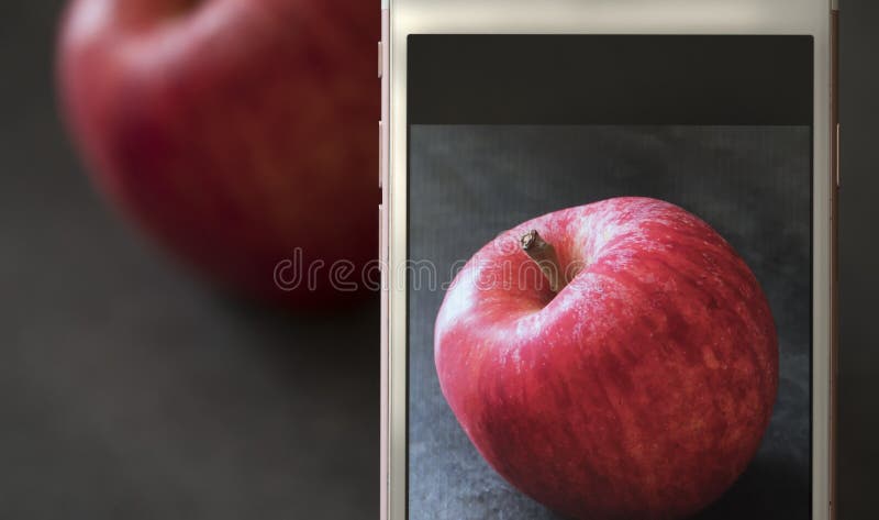 A Picture of Cell-phone Screen while it Focuses on a Red Apple Lying in ...