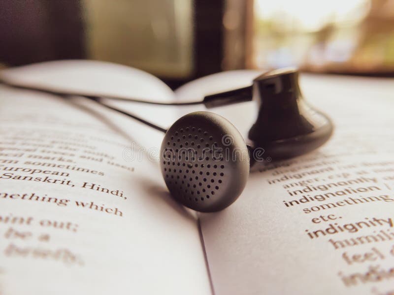 Picture of Earphones on a Book. Stock Photo - Image of earphones, book ...