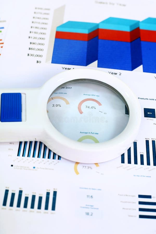 Picture of Financial Graph Paper and Magnifying Glass Stock Photo ...