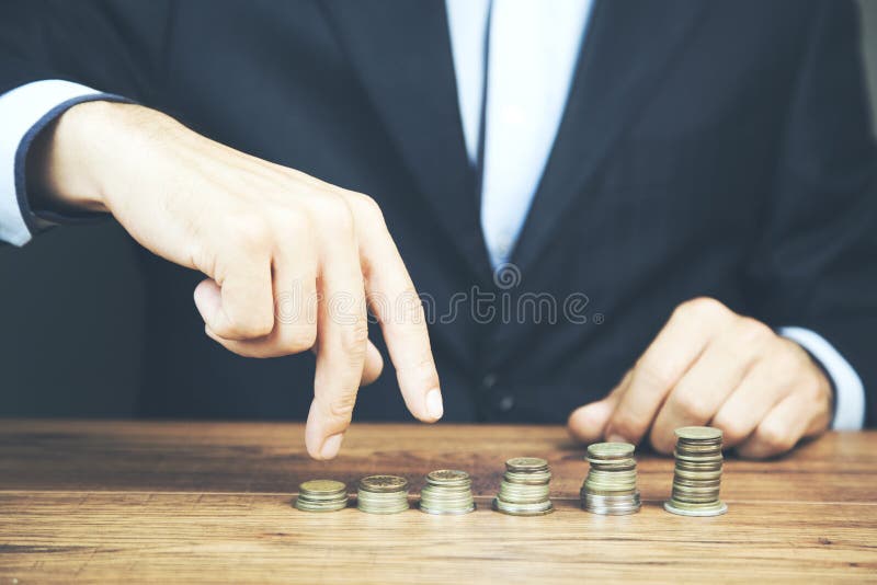 Picture of Man Putting Stack of Coins into One Row Stock Photo - Image ...