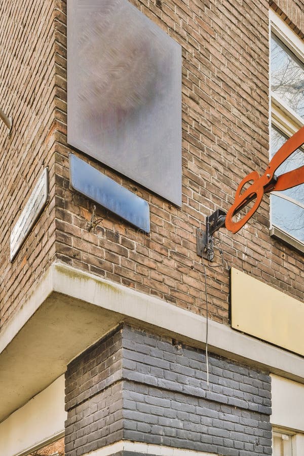 A Picture of an Orange Scissors Hanging on a Building Stock Photo ...