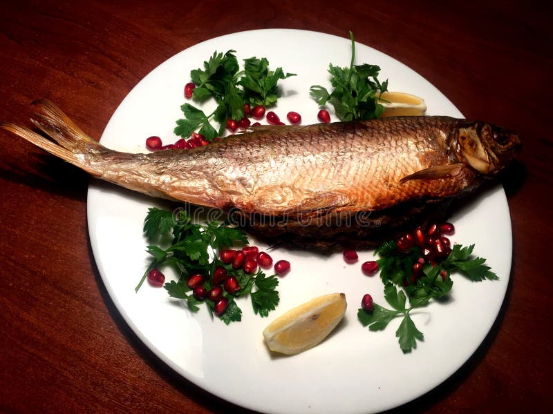 Fried Fish with a Stuffing. Pomegranate and Lemon Stock Image - Image ...