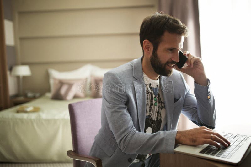 Picture of Young Successful Businessman Talking on Phone and Using ... Picture of Young Successful Businessman Talking on Phone and Using ...