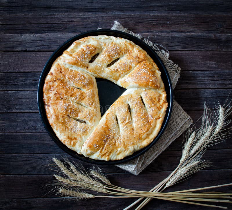 Pie with Sesame on a Sacking and Ears of Wheat. Dark Wooden Background ...