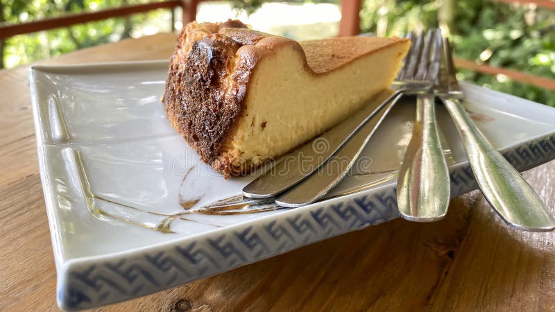 Piece of Cheesecake on a Plate with Forks on a Wooden Tabletop Stock ...