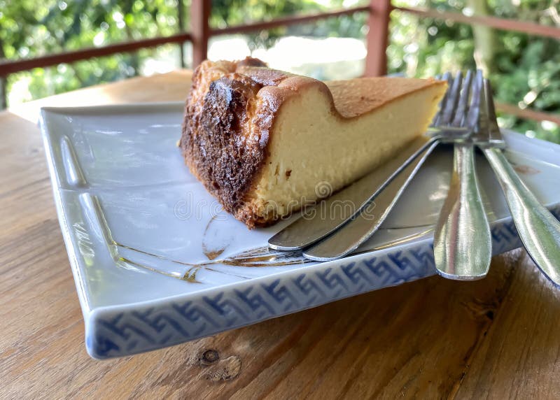 Piece of Cheesecake on a Plate with Forks on a Wooden Tabletop Stock ...
