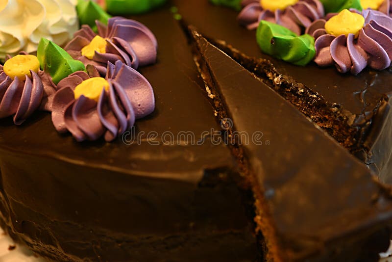 A Piece of Chocolate Cake Cut Off from a Whole Cake with Cream Flowers ...