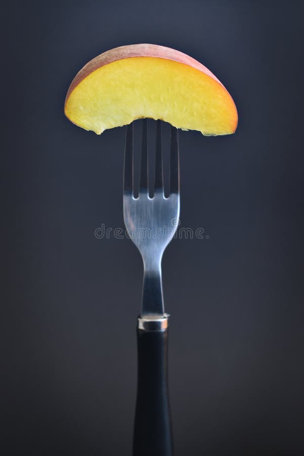 Piece of peach on a fork stock photo. Image of leaf - 107657054