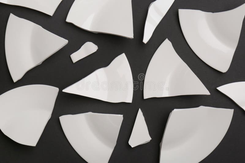 Pieces of Broken White Ceramic Plate on Dark Grey Background, Flat Lay ...