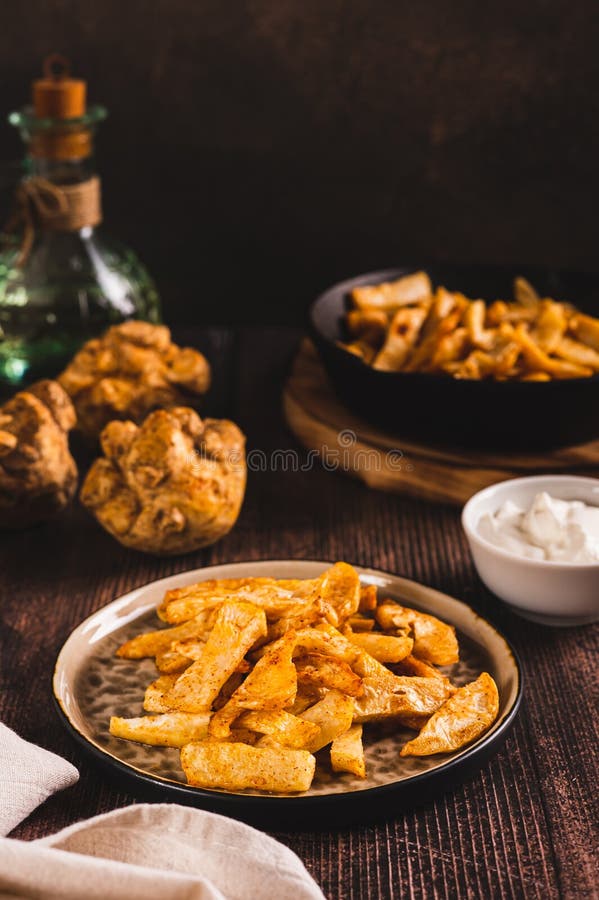 Pieces of Celery Root Fried with Paprika on a Plate on the Table ...