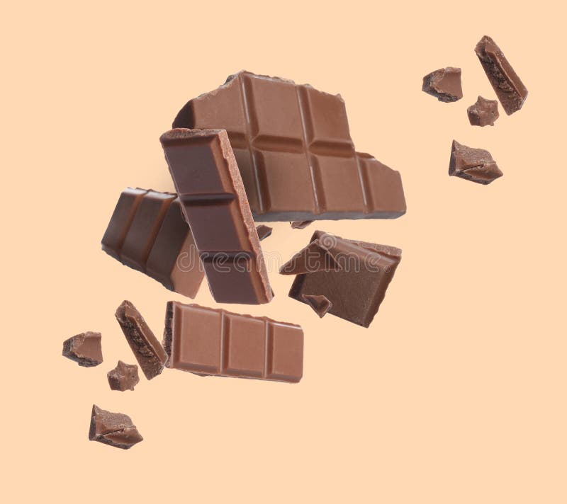 Pieces of Chocolate Bar Falling on Beige Background Stock Photo - Image ...