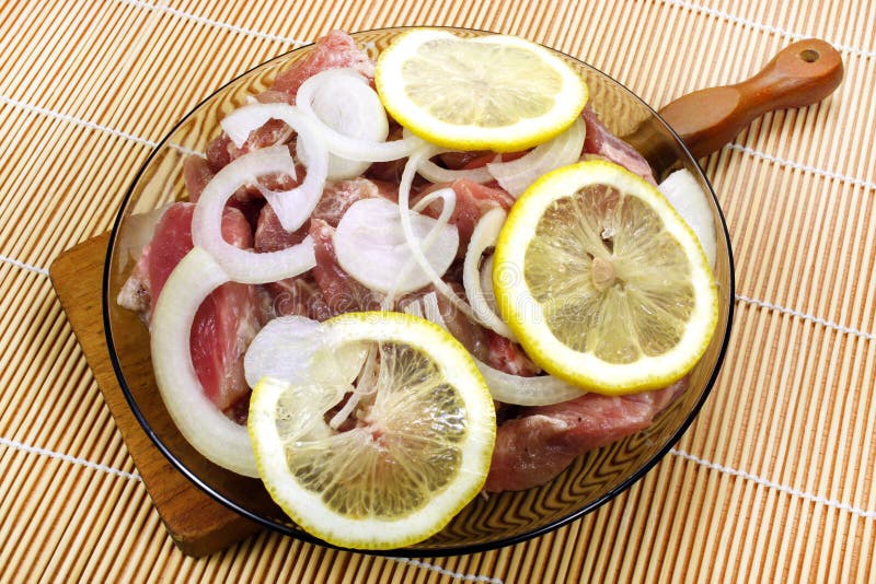 Pieces of Fresh Meat with Onions and a Lemon Stock Photo - Image of ...