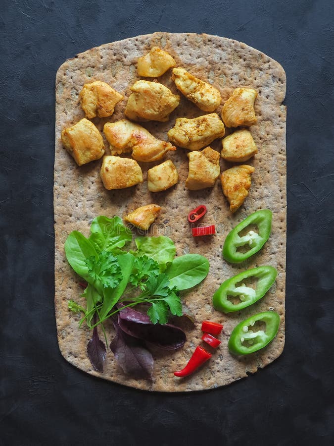Pieces of Fried Chicken Curry Fillet on Rye Flatbread with Vegetables ...