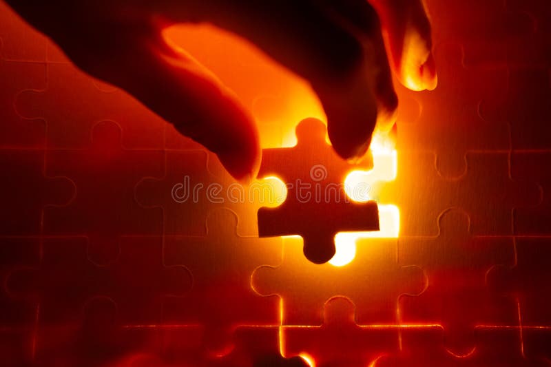 Pieces of a Jigsaw Puzzle Filled with Orange Lights by Hand Success ...