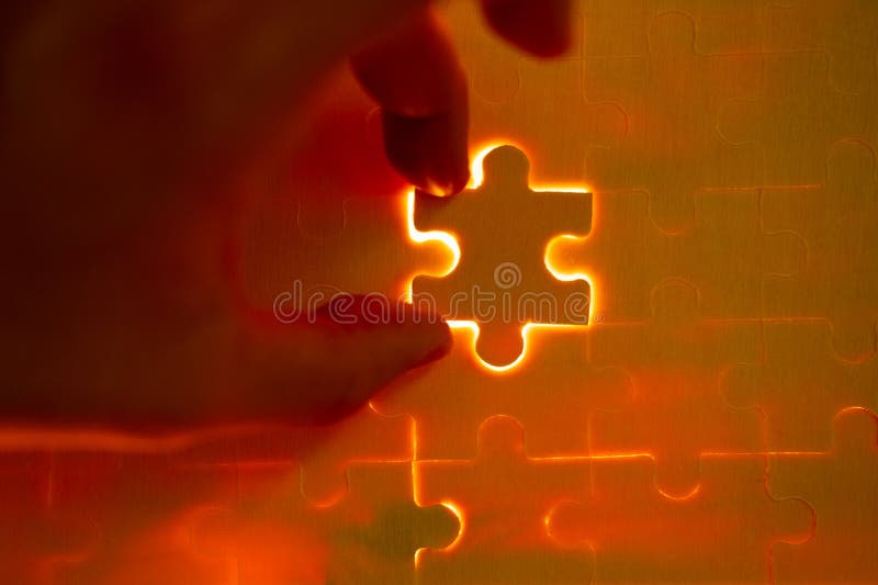 Pieces of a Jigsaw Puzzle Filled with Orange Lights by Hand Success ...