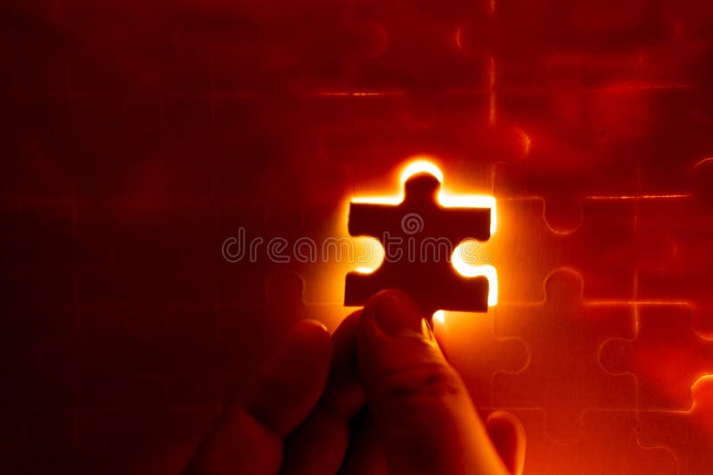 Pieces of a Jigsaw Puzzle Filled with Orange Lights by Hand Success ...
