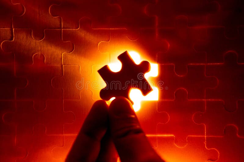 Pieces of a Jigsaw Puzzle Filled with Orange Lights by Hand Success ...