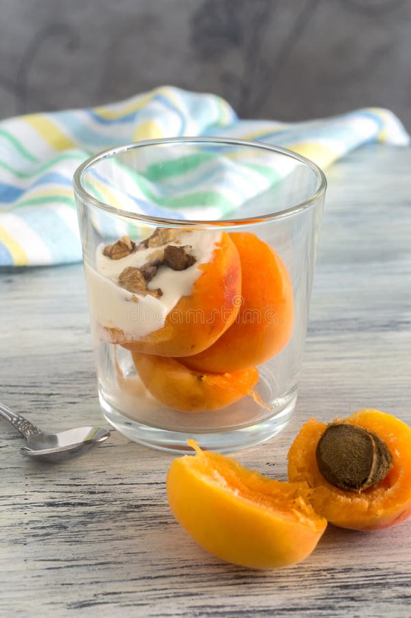 Pieces of Peach with Cream and Nuts with a Glass. Peach with a Stone in ...