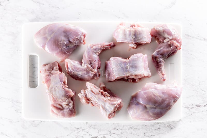 Pieces of Portioned Rabbit on a White Cutting Board - Top of View Stock ...