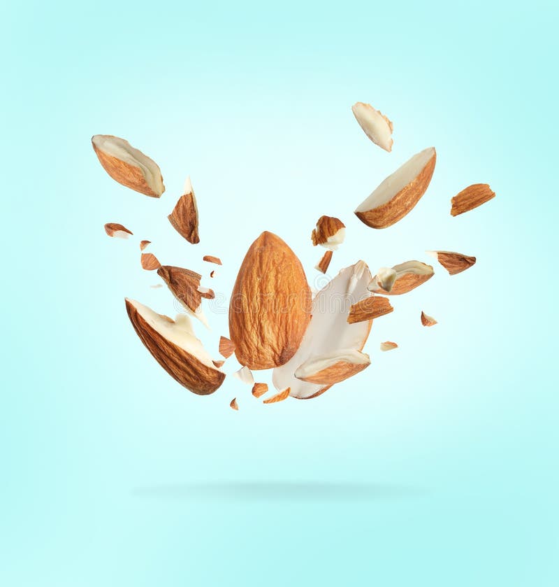 Pieces of Tasty Almonds Falling on Light Blue Background Stock Image ...