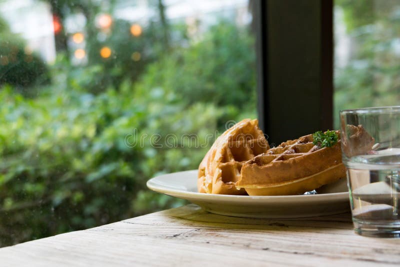 2 Pieces of Waffle with a Glass of Water on the Wooden Table - Apply ...