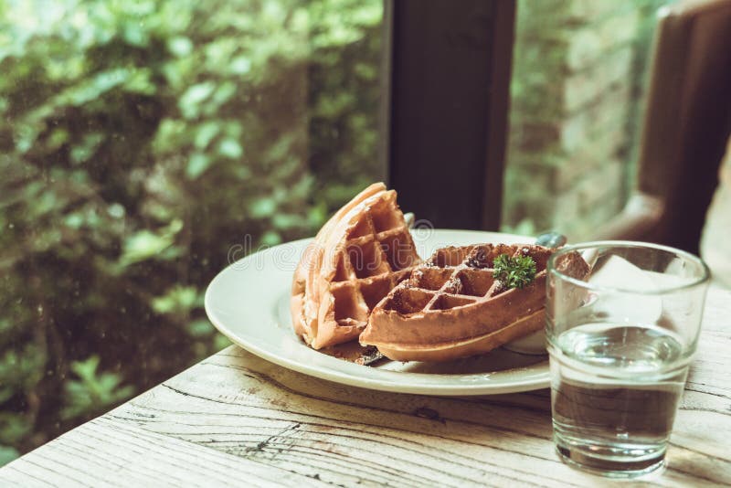 2 Pieces of Waffle with a Glass of Water on the Wooden Table - Apply ...