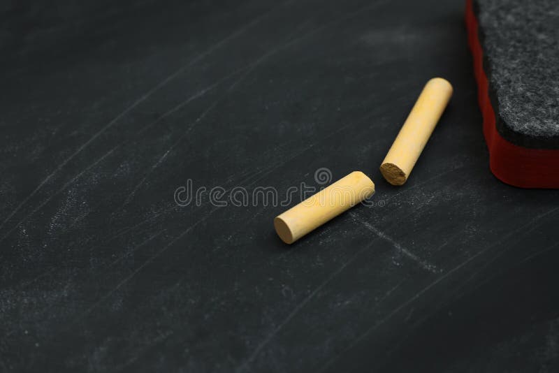 Pieces of Yellow Chalk and Duster on Black Board, Closeup. Space for ... Pieces of Yellow Chalk and Duster on Black Board, Closeup. Space for ...