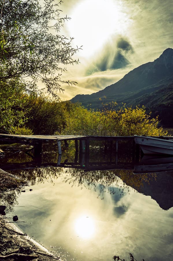 Pier in Calm Water Reflecting the Forest and the Sky. Vertical Stock ...