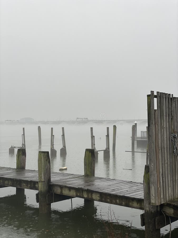 Pier through the Fog with Bridge in the Background Stock Photo - Image ...