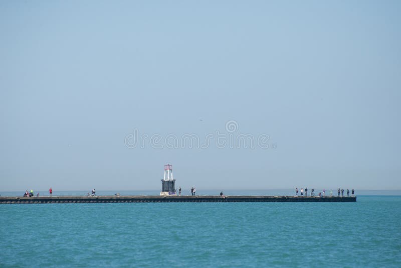 A Pier with a Lighthouse and a Group of People Standing on it Editorial ...