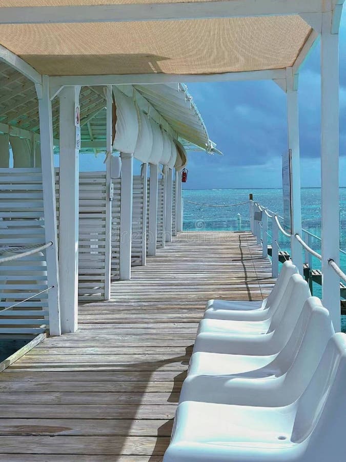 Pier with White Chairs Facing the Ocean Stock Image - Image of seaside ...
