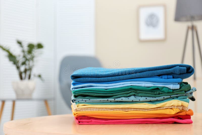 Pila De Ropa Doblada Brillante En La Tabla Dentro Foto de archivo ...