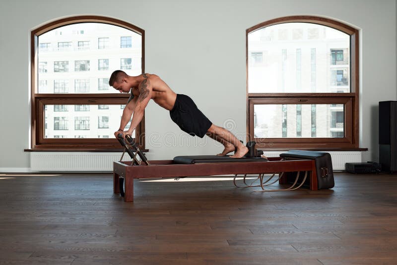 Pilates Reformer Workout Exercises Man at Gym Indoor. Stock Photo ...
