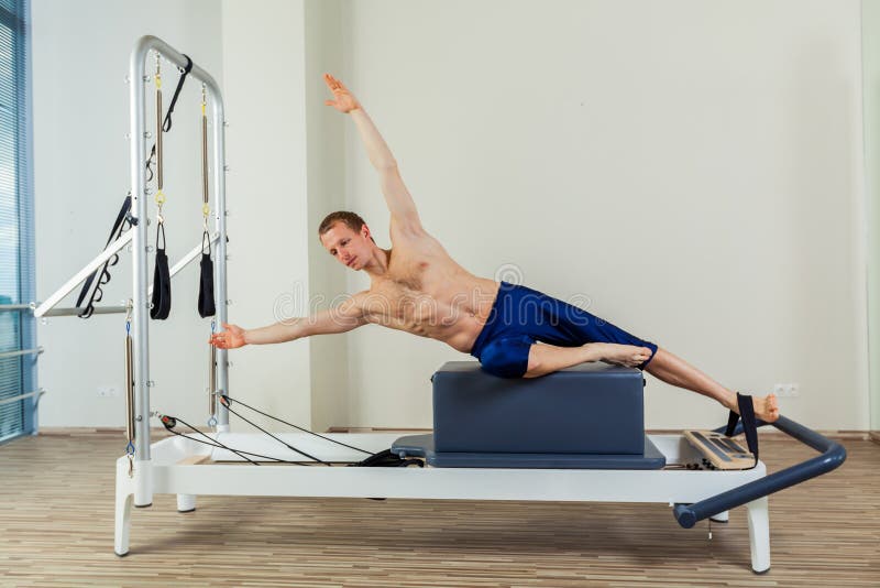 Pilates Reformer Workout Exercises Man at Gym Indoor. Stock Photo ...