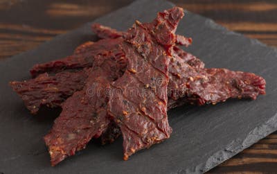 Pile of Black Pepper Beef Jerky on a Rustic Wooden Table Stock Photo ...