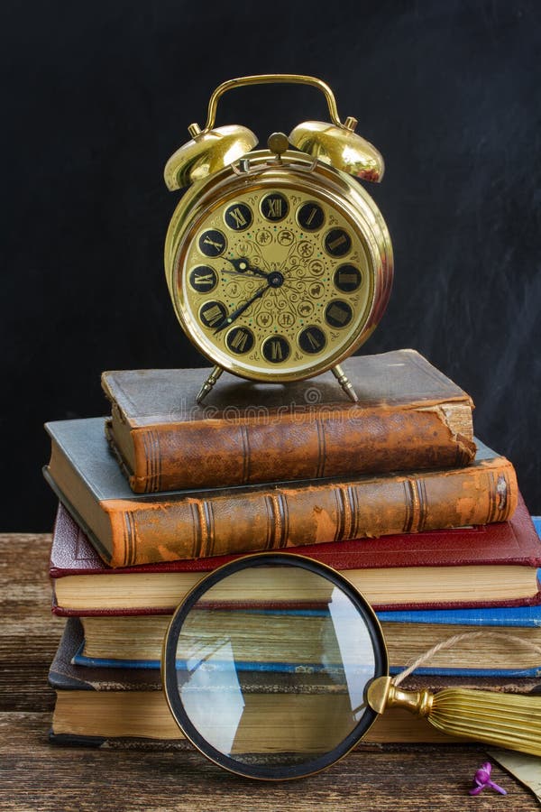 Pile of books with clock stock photo. Image of design - 55081192