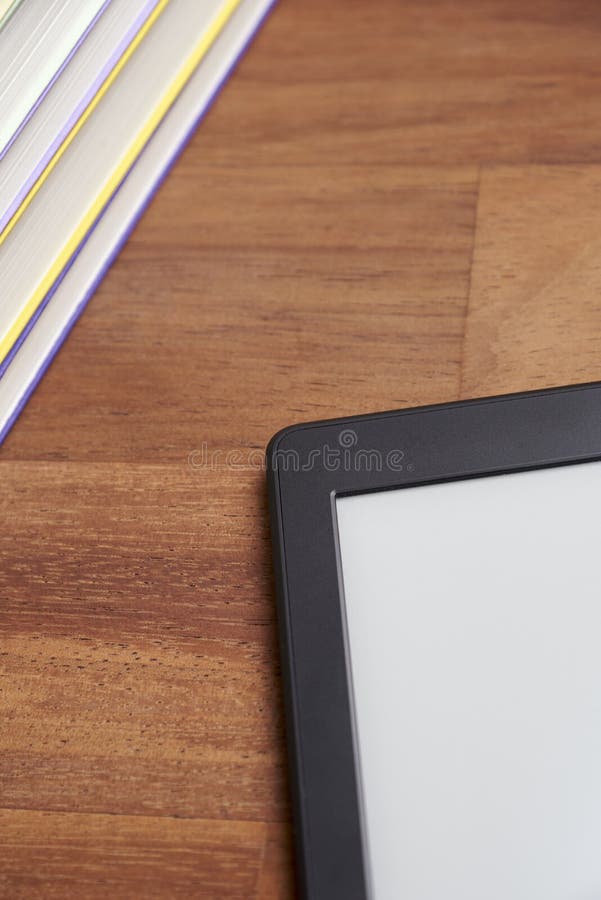 Pile of Books and Electronic Reader with Blank Screen on a Wooden ...