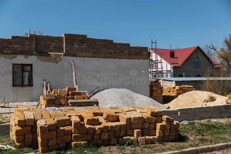 A Pile of Bricks Lies in Front of the House that is Being Built Stock ...
