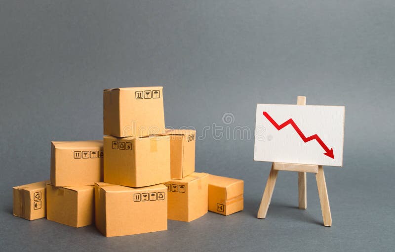 A Pile of Cardboard Boxes and Easel with Red Arrow Down. Decrease in ...