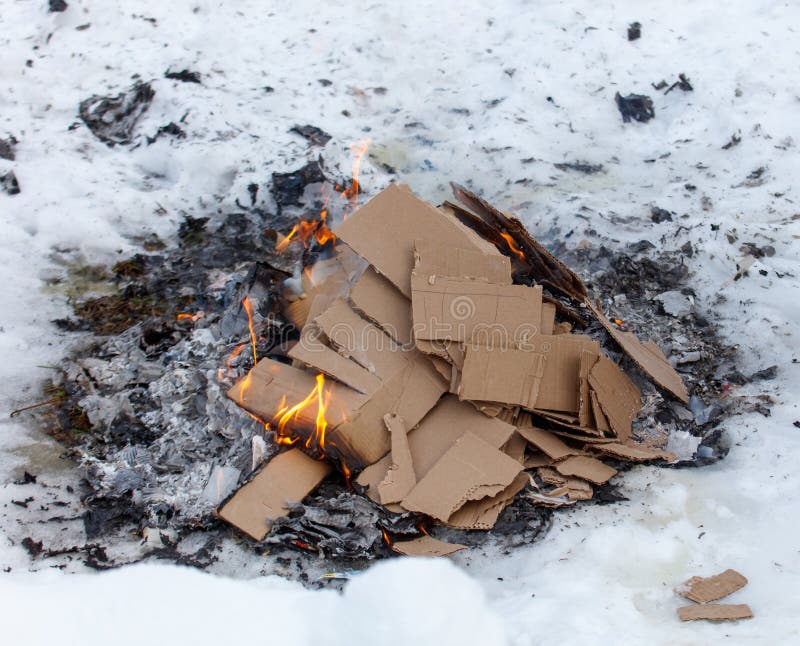 A Pile of Cardboard is on the Ground with a Fire Burning in it Stock ...
