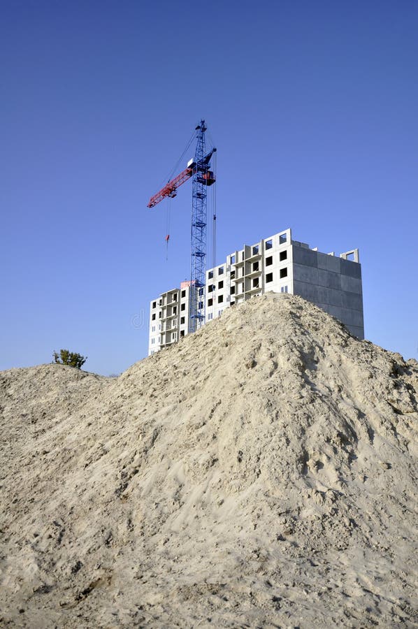 A Pile of Construction Sand in Front of Buildings Under Construction ...