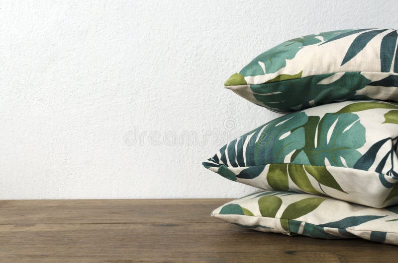 Pile of Cushions with Floral Fabric on the Brown Floor Against White ...