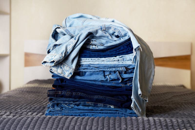 A Pile of Denim Clothes on the Bed Stock Image - Image of casual, jean ...