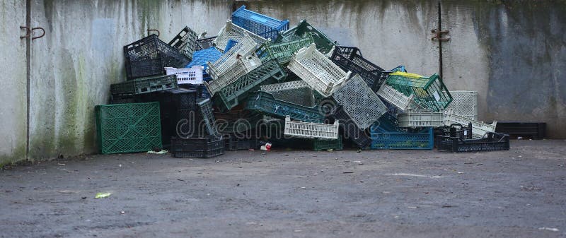 Pile of Discarded Plastic Crates Against a Gray Concrete Wall Stock ...