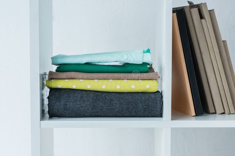 Pile of Folded Colored Fabric with Stack of Books Stock Photo - Image ...