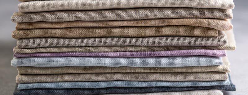 A Pile of Four Folded Dull-colored Natural Linen Fabric Stock Photo ...