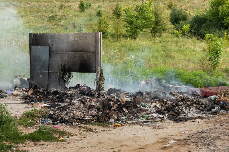 A Pile of Garbage Burns and Smokes in an Open Area. Pollution of the ...