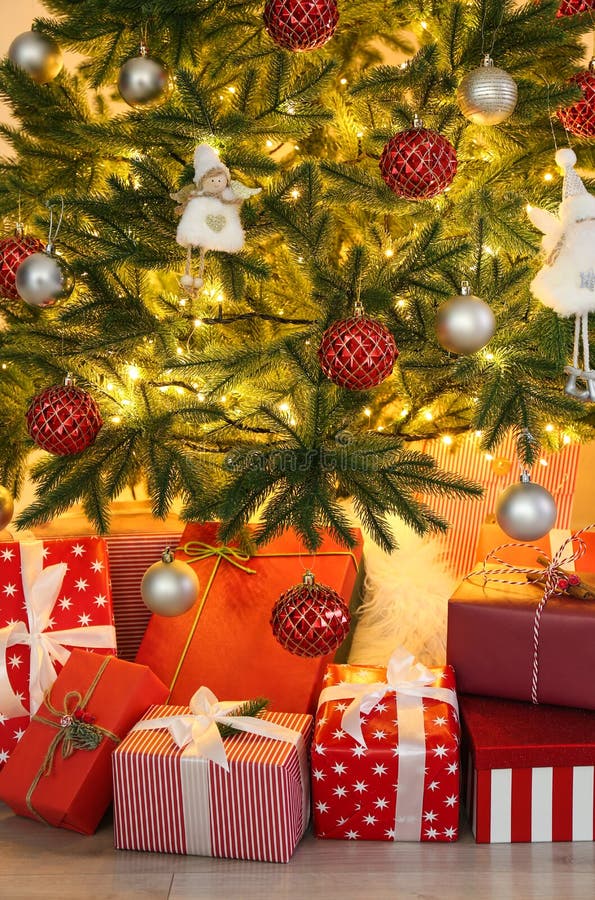 Pile of Gift Boxes Near Christmas Tree Indoors Stock Photo - Image of ...