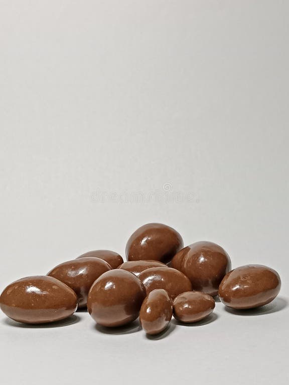 A Pile of Glossy, Oval-shaped Chocolate-coated Almonds Arranged on a ...