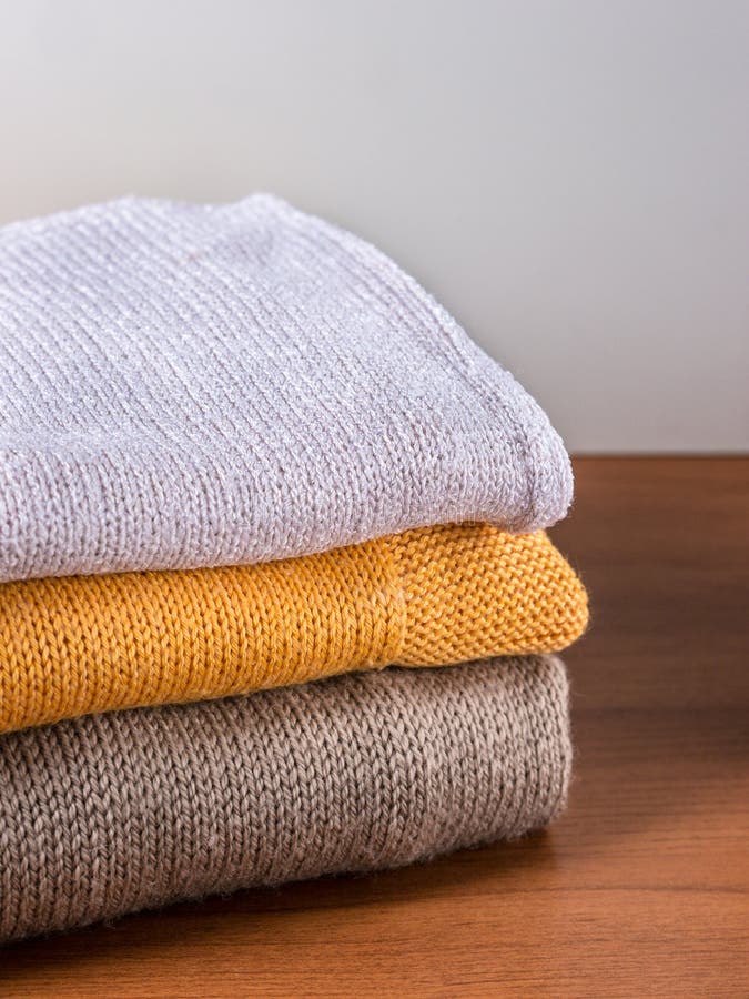 Pile Knit Wear on Wooden Table Stock Photo - Image of clothes, knitted ...